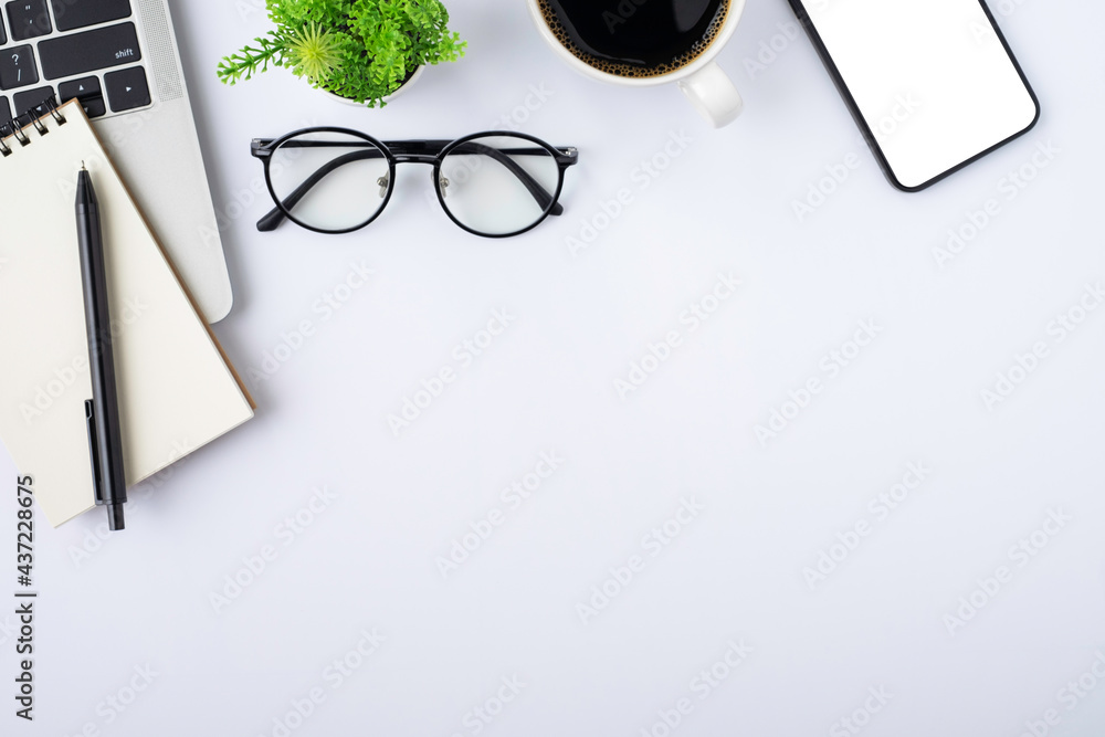Top view above of White office desk table with keyboard, notebook and ...
