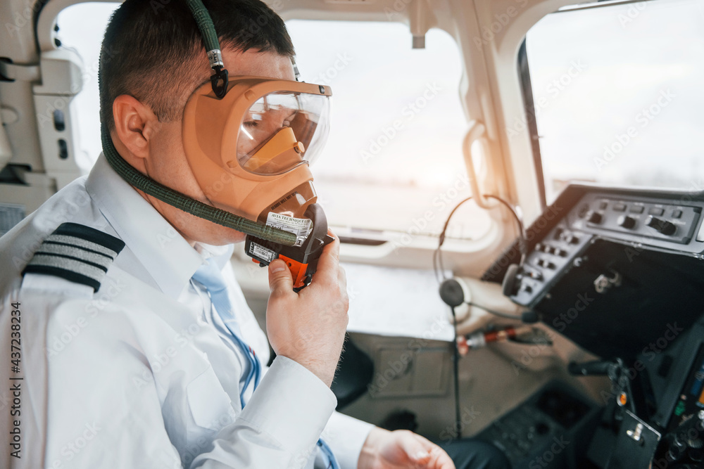 In oxygen mask. Pilot on the work in the passenger airplane. Preparing ...