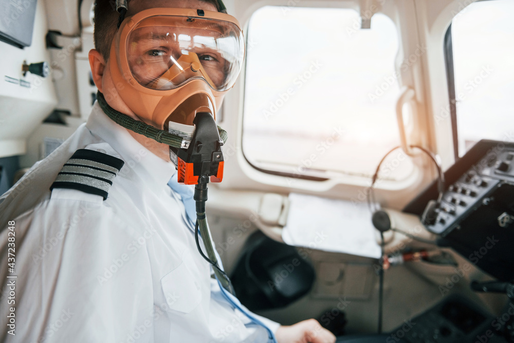 In oxygen mask. Pilot on the work in the passenger airplane. Preparing ...