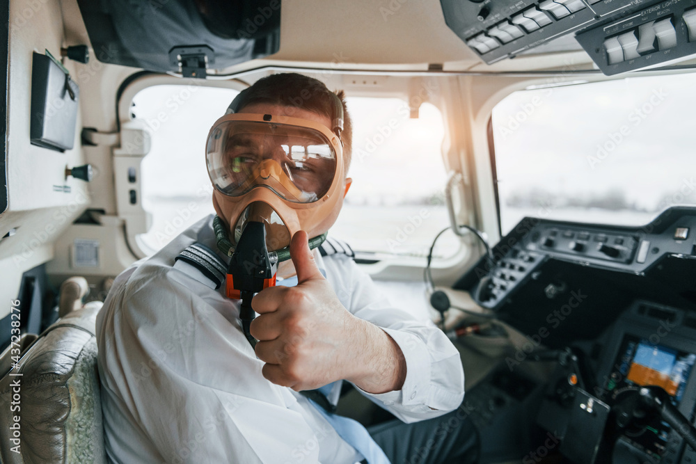 In oxygen mask. Pilot on the work in the passenger airplane. Preparing ...