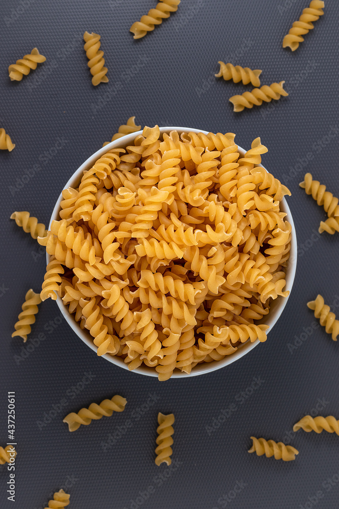 Raw uncooked spiral pasta in bowl. Raw pasta, macaroni, Dry spiral ...