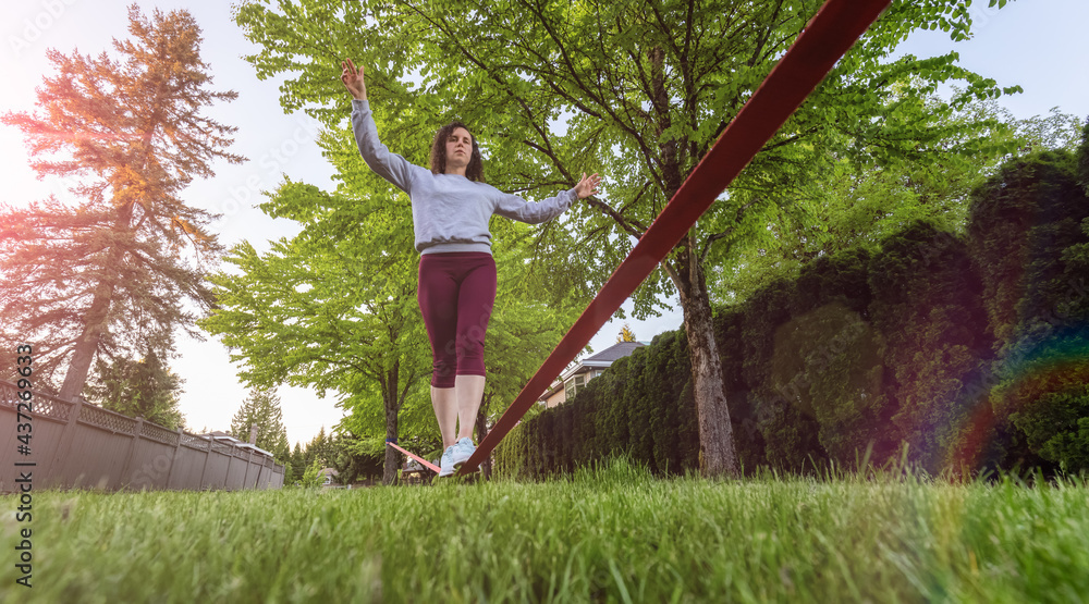 Adventurous White Caucasian Adult Woman walking on a Slackline between ...