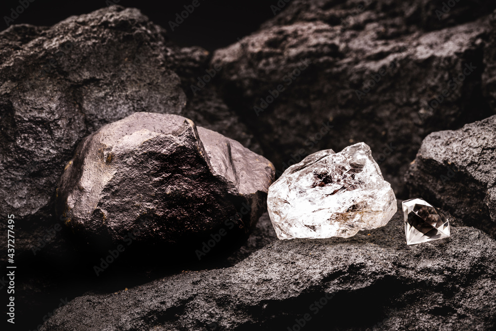 rough diamond next to a cut diamond, and coal stone in a coal mine ...