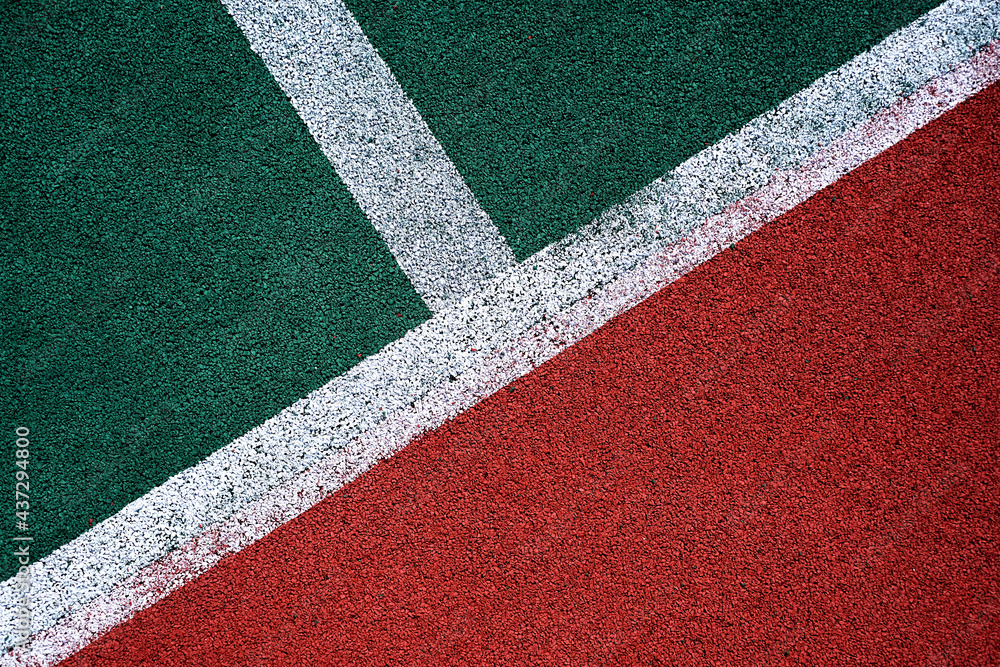 floor covering on a soccer field red green with white lines close-up ...