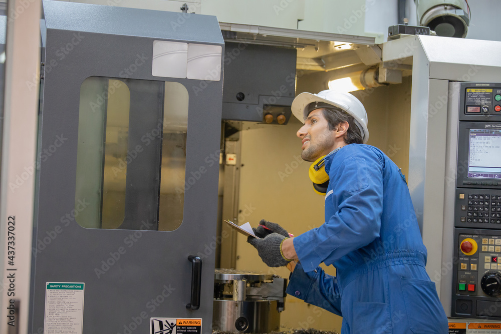 Workers inspecting workpieces from CNC machines. The worker measures ...