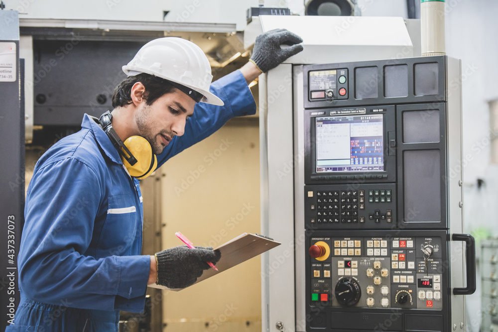 Workers inspecting workpieces from CNC machines. The worker measures ...