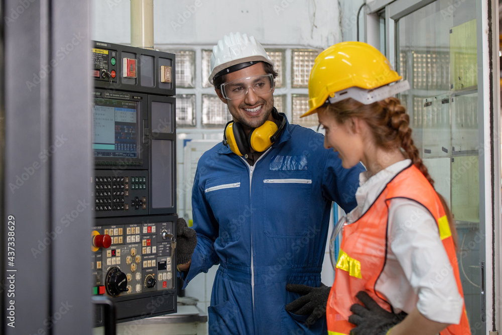 Engineer Training Apprentices On CNC Machine. Factory worker is ...