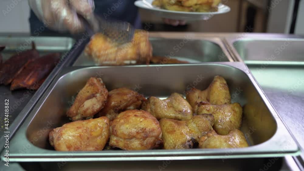 Grilled chicken wings are placed on a plate and served to the visitor ...