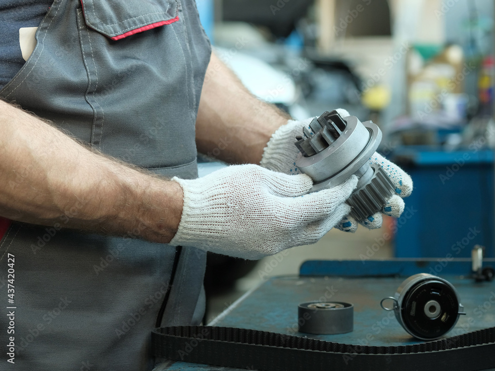 A water pump in the hands of a car mechanic.Set of gas distribution ...