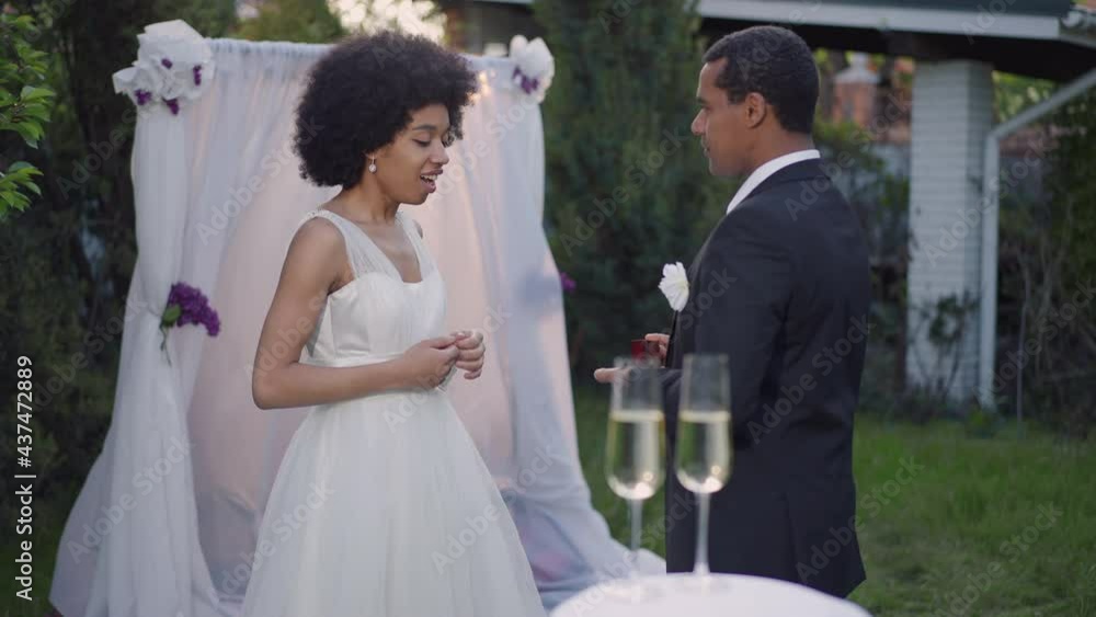 Medium shot side view of young African American man in wedding suit ...