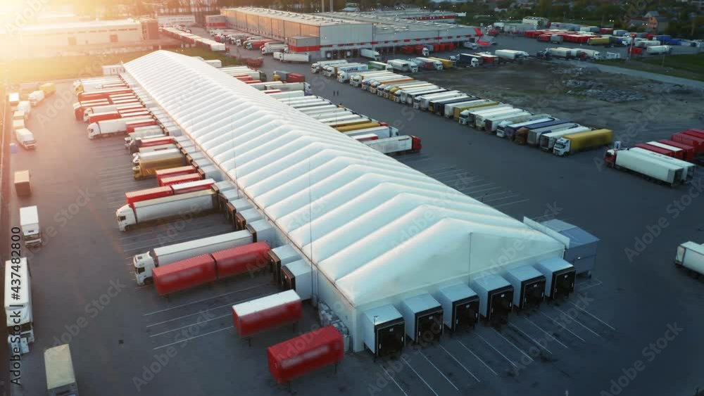 Modern warehouse in a logistics park. Many semi-trailer trucks are ...