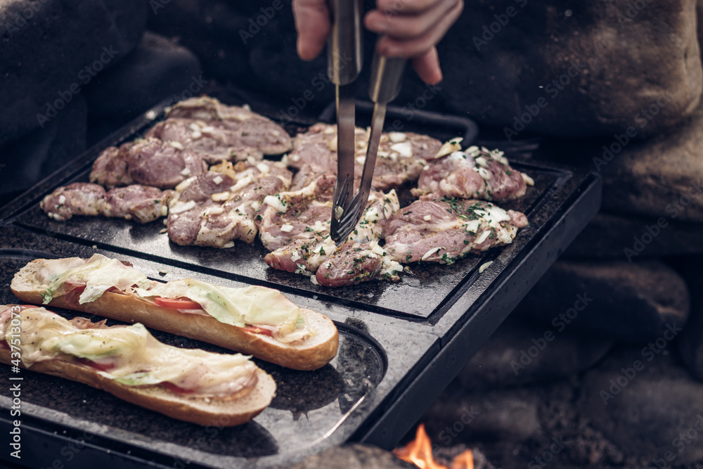 Man prepares a juicy pork neck with basil and barbecue spices and a ...