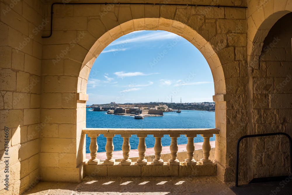 View through historic stone window with arch and balustrade to the sea ...