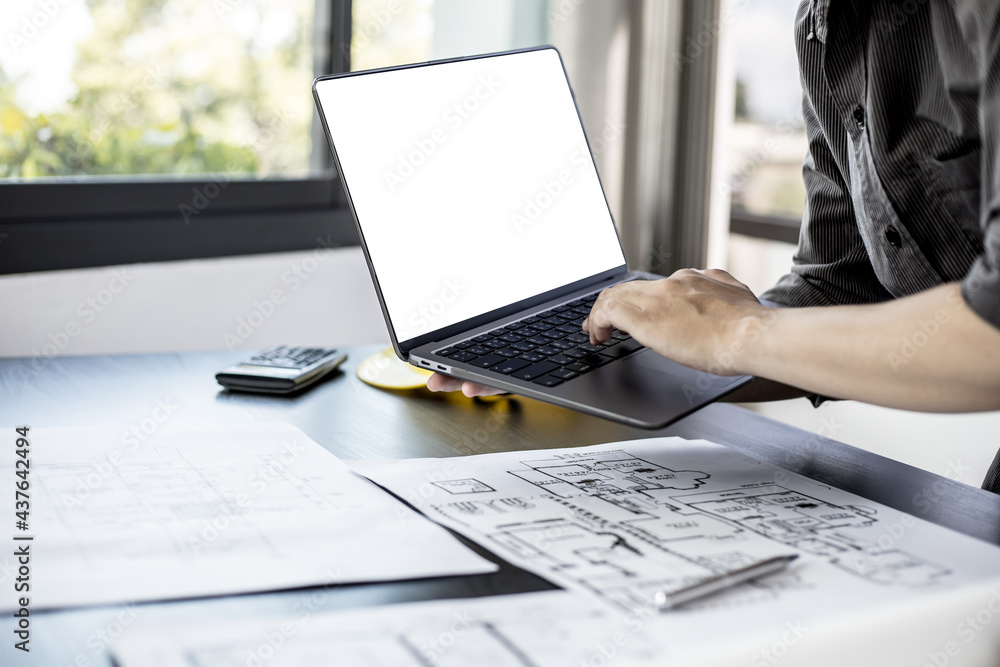Architect engineers are using laptops to check house plans and print ...