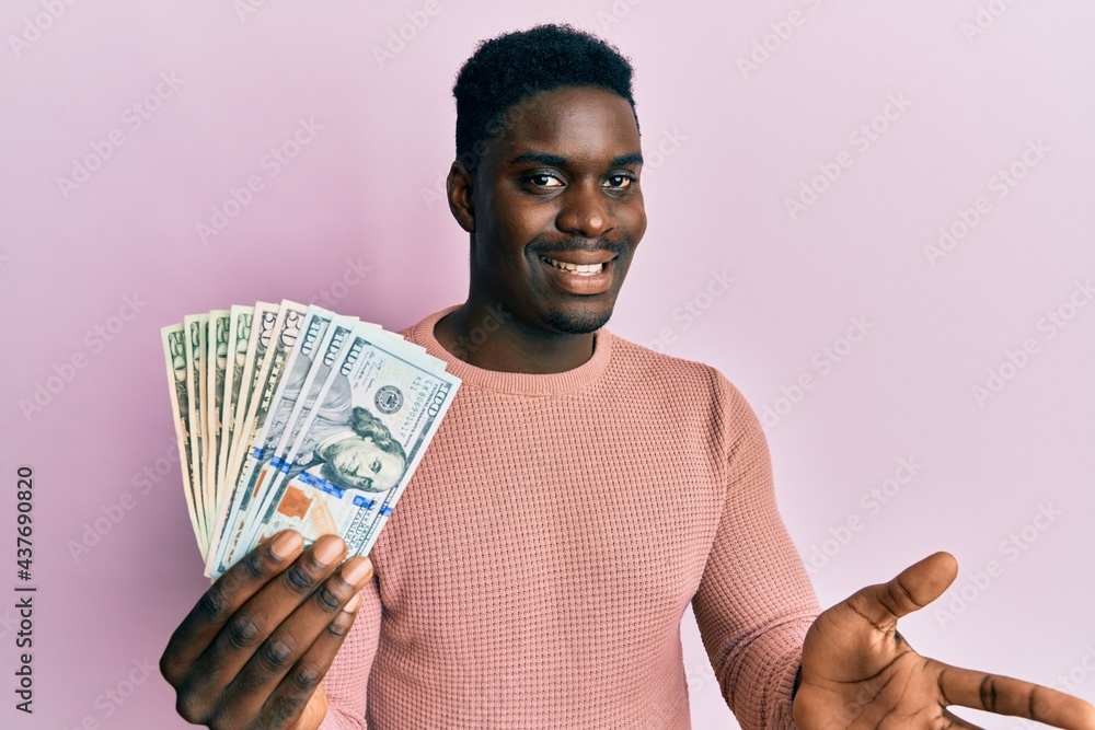 Handsome black man holding dollars celebrating achievement with happy ...