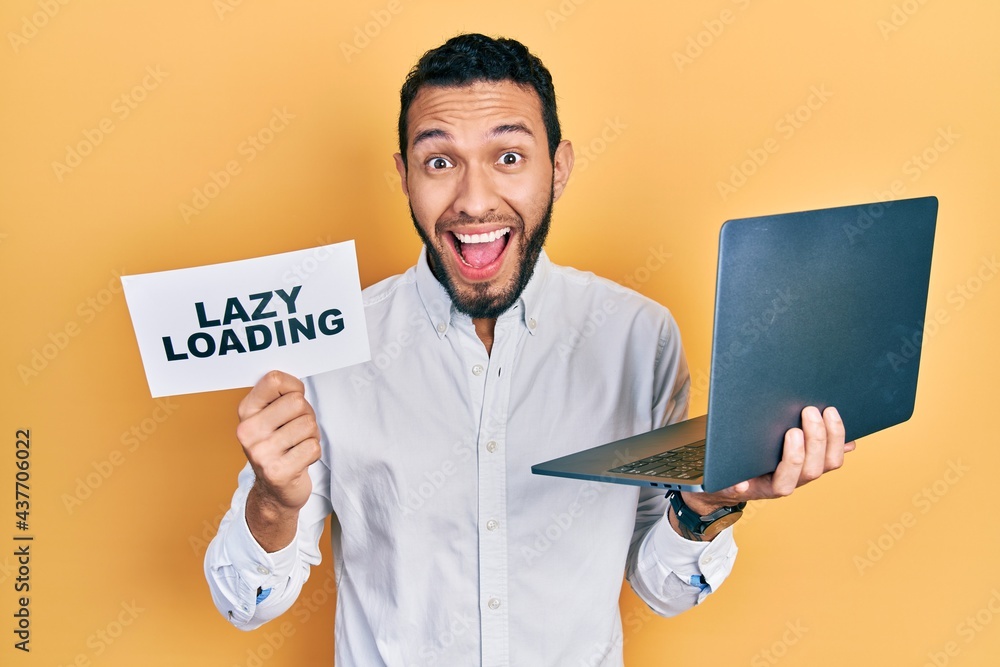 Hispanic man with beard working using computer laptop holding lazy ...