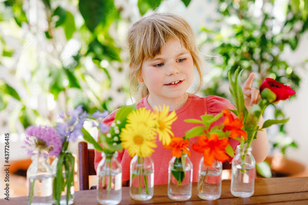 Little preschool girl making flower bouquet at home. Toddler child ...