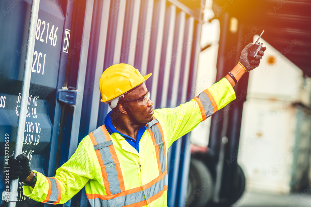 Black African worker working in logistic shipping radio control order ...