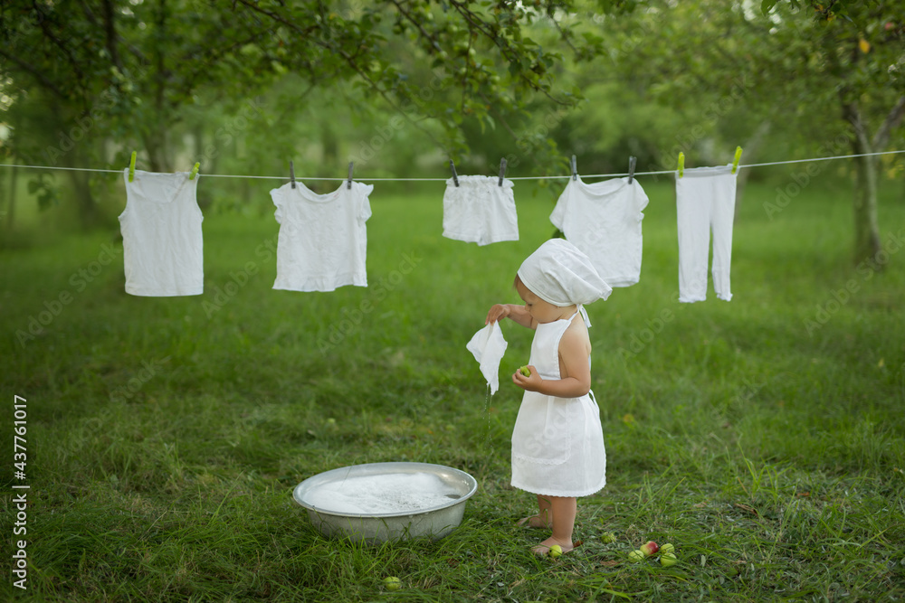 Fotografia do Stock: A child cheerfully launderes his clothes in the ...