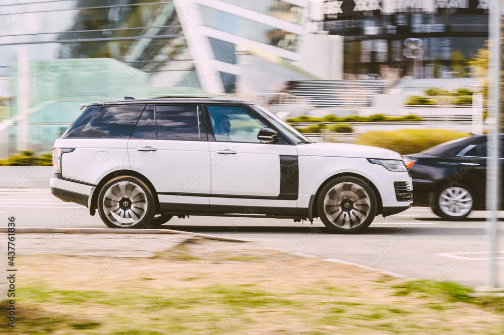 White Range Rover L405 car moving on the street on high speed. Fast ...