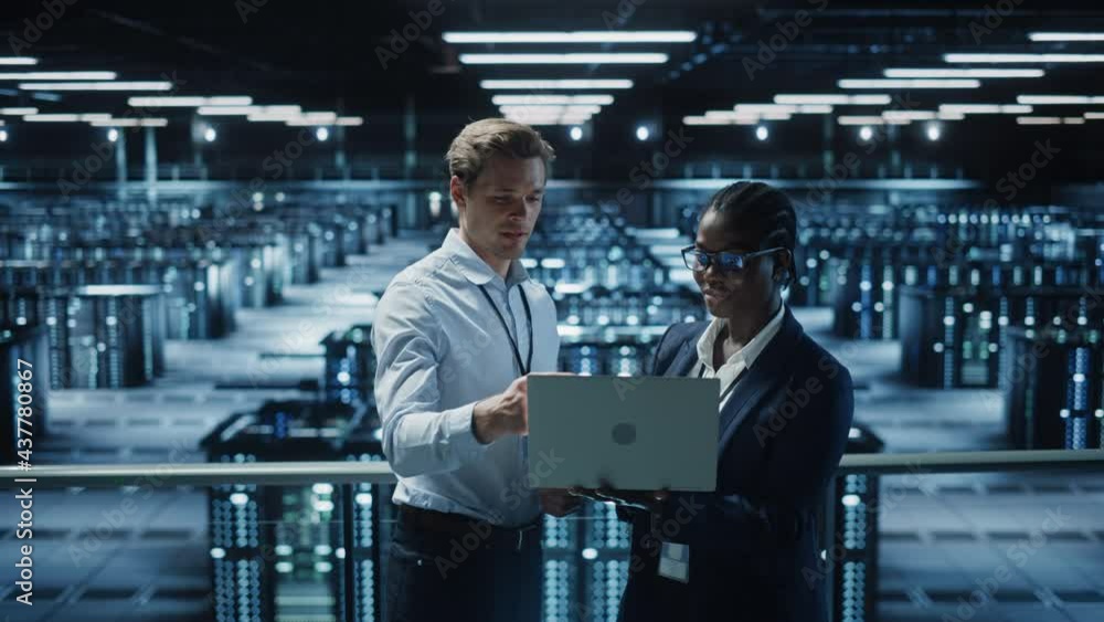 Data Center Female System Administrator and Male IT Specialist talk ...