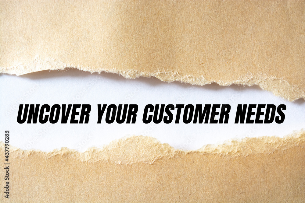 Text Uncover Your Customer Needs appearing behind torn paper. Concept ...