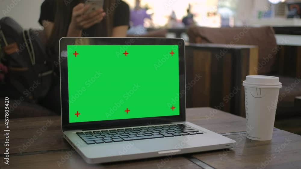 Chroma key green screen laptop computer set up for work on a cafe desk ...