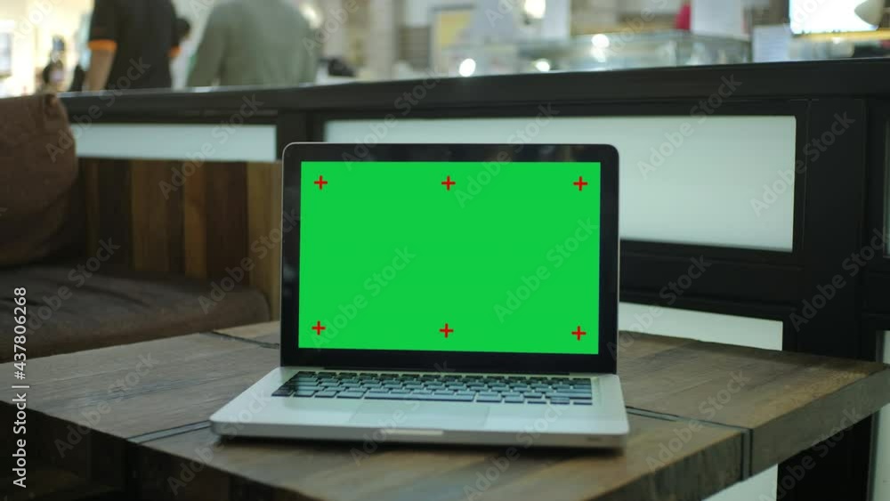 Chroma key green screen laptop computer set up for work on a cafe desk ...