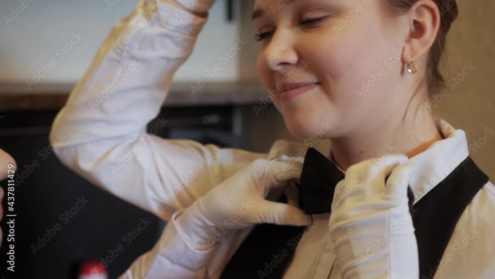 Woman waitress ties bow tie for girlfriend in elite restaurant. Female ...