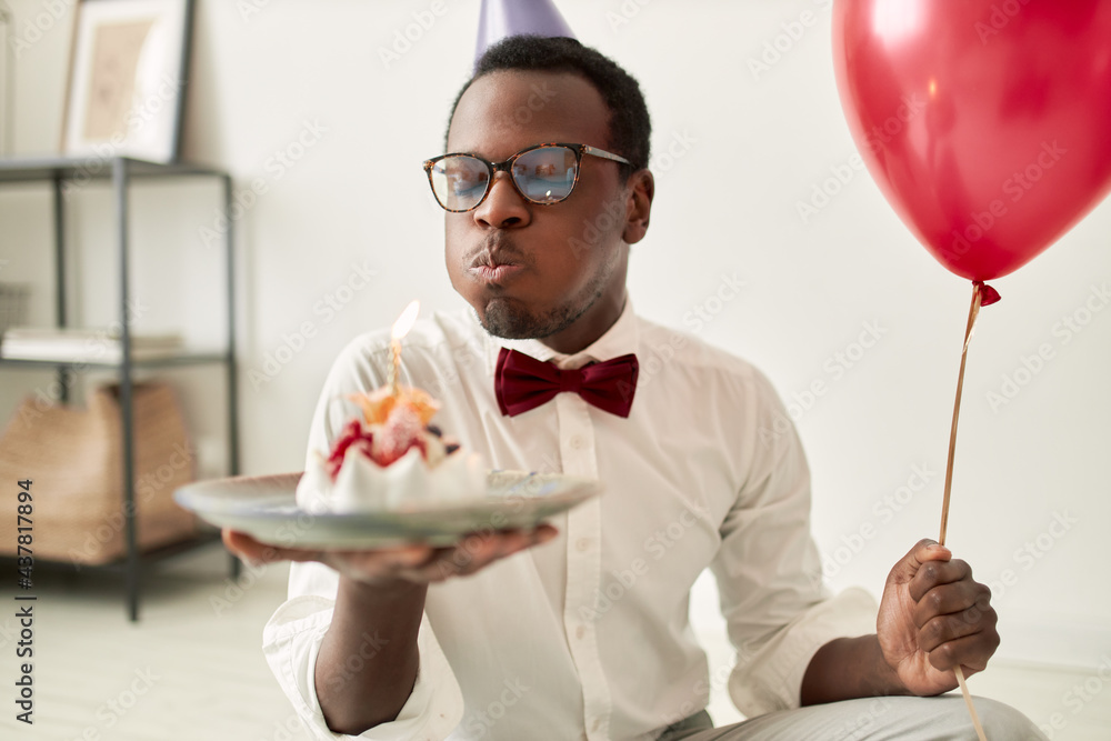 Foto Stock Joyful young African man in elegant clothing and cone hat ...