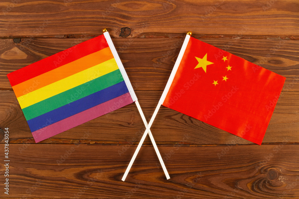 Rainbow flag LGBT and flag of China on brown wood planks background ...