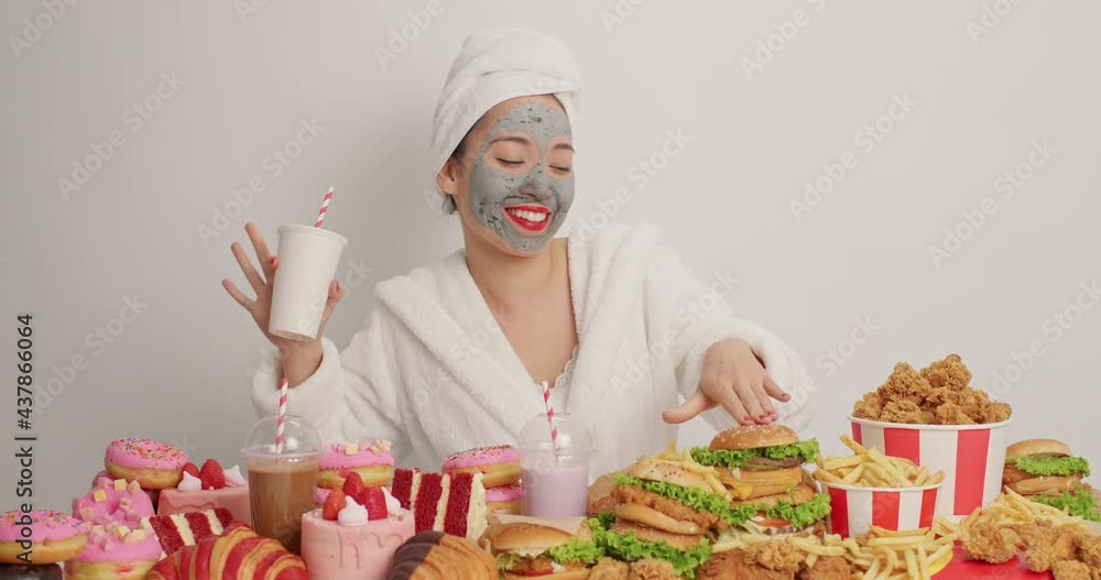 Funny Asian woman foolishes around eats fast food dances carefree ...