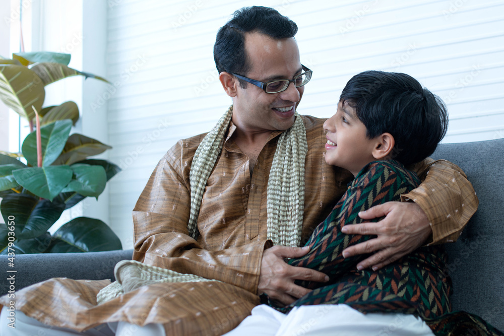 Indian father and son wearing traditional suit express love with a hug ...