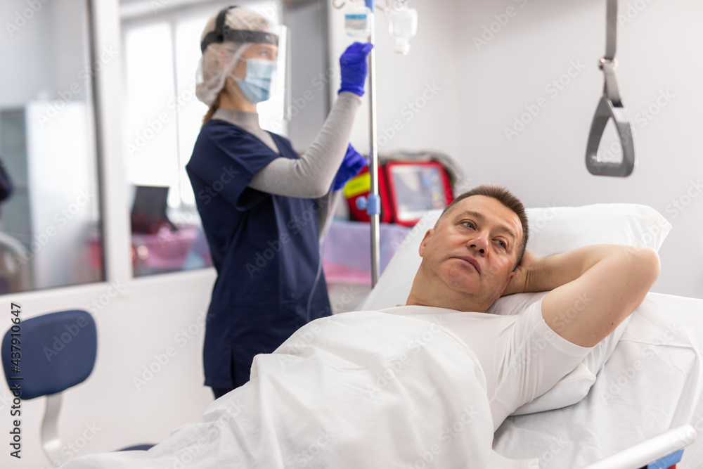 Adult patient lying on bed during intravenous injection by dropping ...