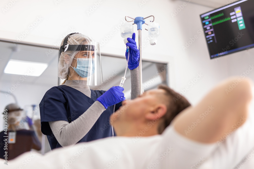 Adult patient lying on bed during intravenous injection by dropping ...