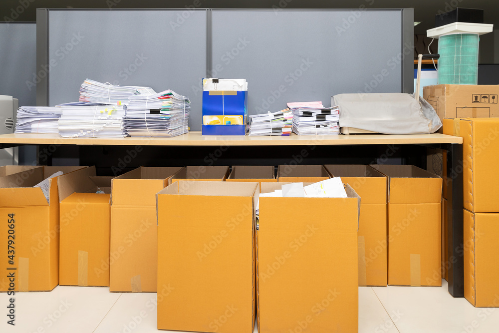 Business documents stack on desk and cardboard boxes under desk in ...