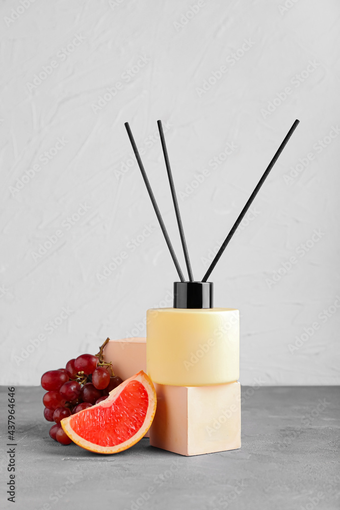 Reed diffuser with fruits on table against light background Stock Photo ...