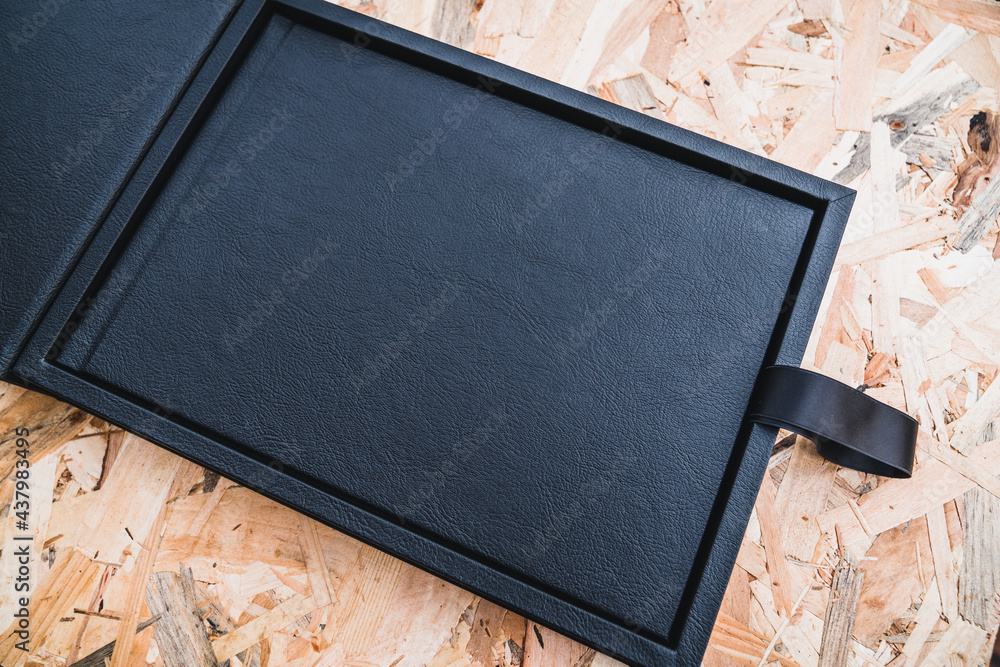 Black leather photo album on a table with vintage wood background ...
