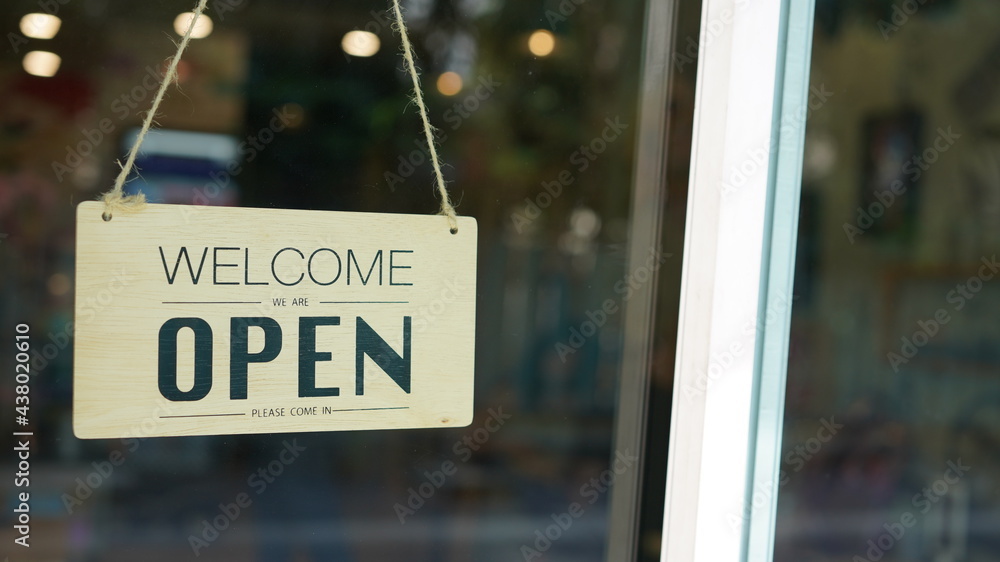 Open and closed flip sign in front of coffee shop and restaurant glass ...