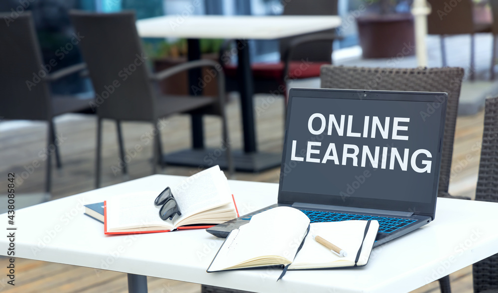 Open laptop inscription on the screen text online learning. Table in a ...