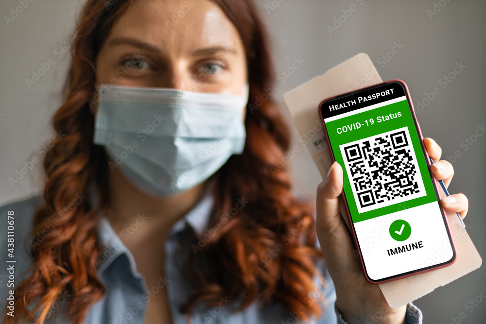 Traveler woman wearing a face mask holding a passport, ticket pass and ...