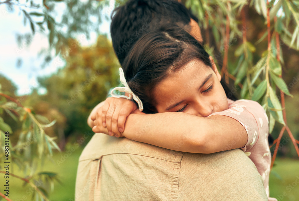 Rear view of a daughter hugging her loving father during spending time ...
