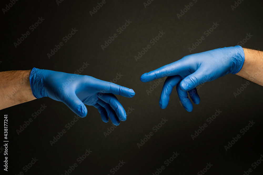 Two hands in medical gloves that reach out to each other resembling ...