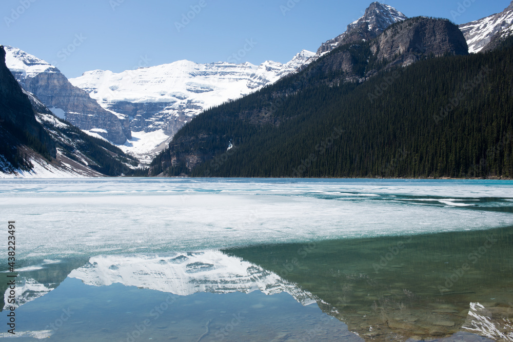 Beautiful scene with Lake Louise partially frozen and the mountains ...