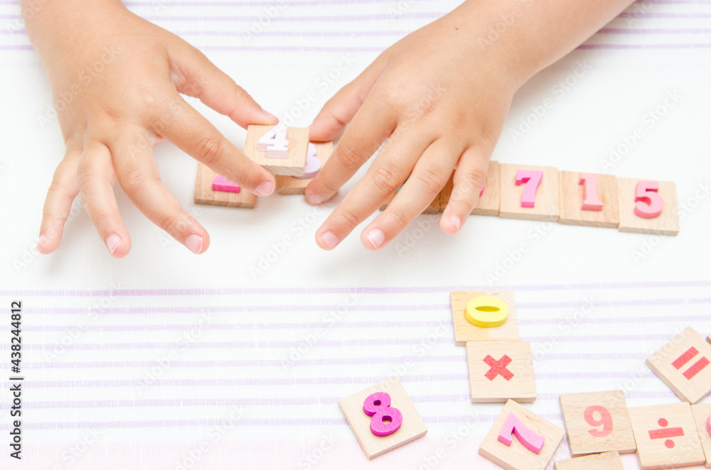 Child plays with wooden numbers, makes a chain of cisels, simple ...