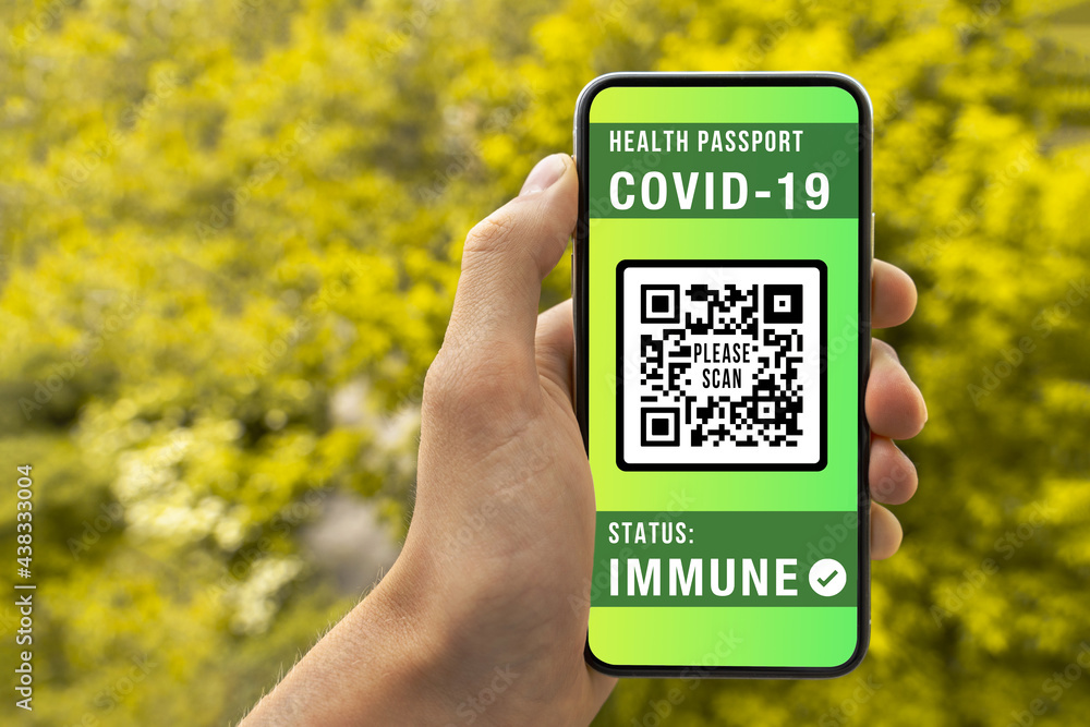 A hand holds the smartphone with a digital illustration of a Covid-19 ...