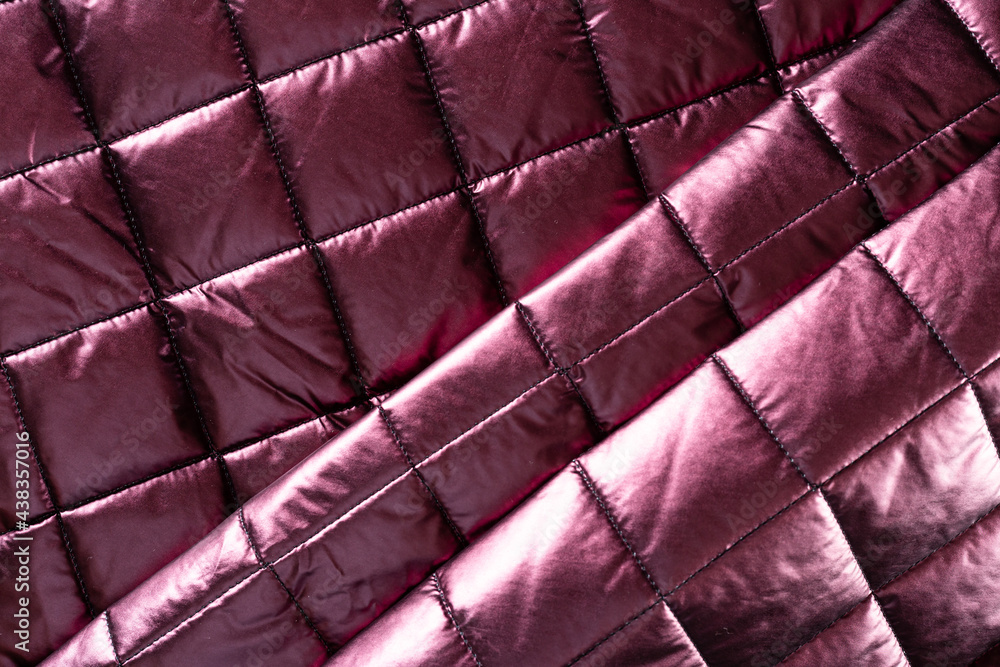 wine-colored surface of jacket fabric with padding polyester folded ...