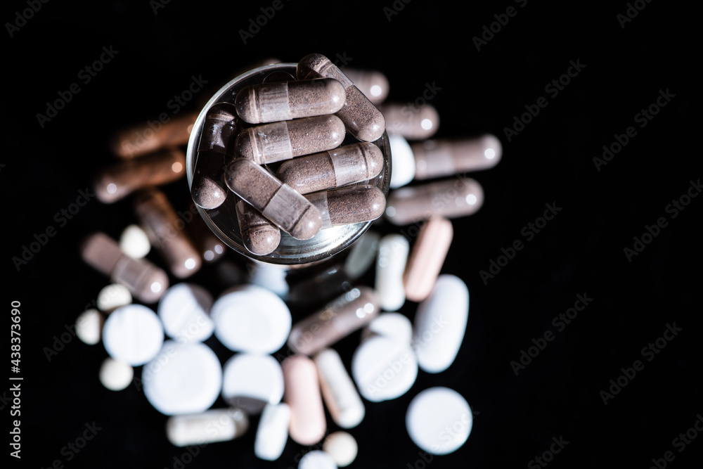 Starch capsules gel caps medication in glass dark background, caplets ...