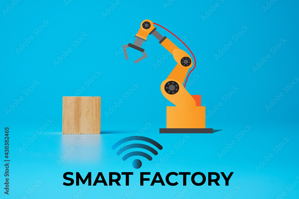 A picture of robotic arm ready to carry wooden block with smart factory ...