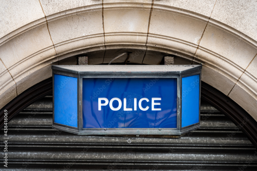Traditional old fashioned retro blue police sign above arched stone ...